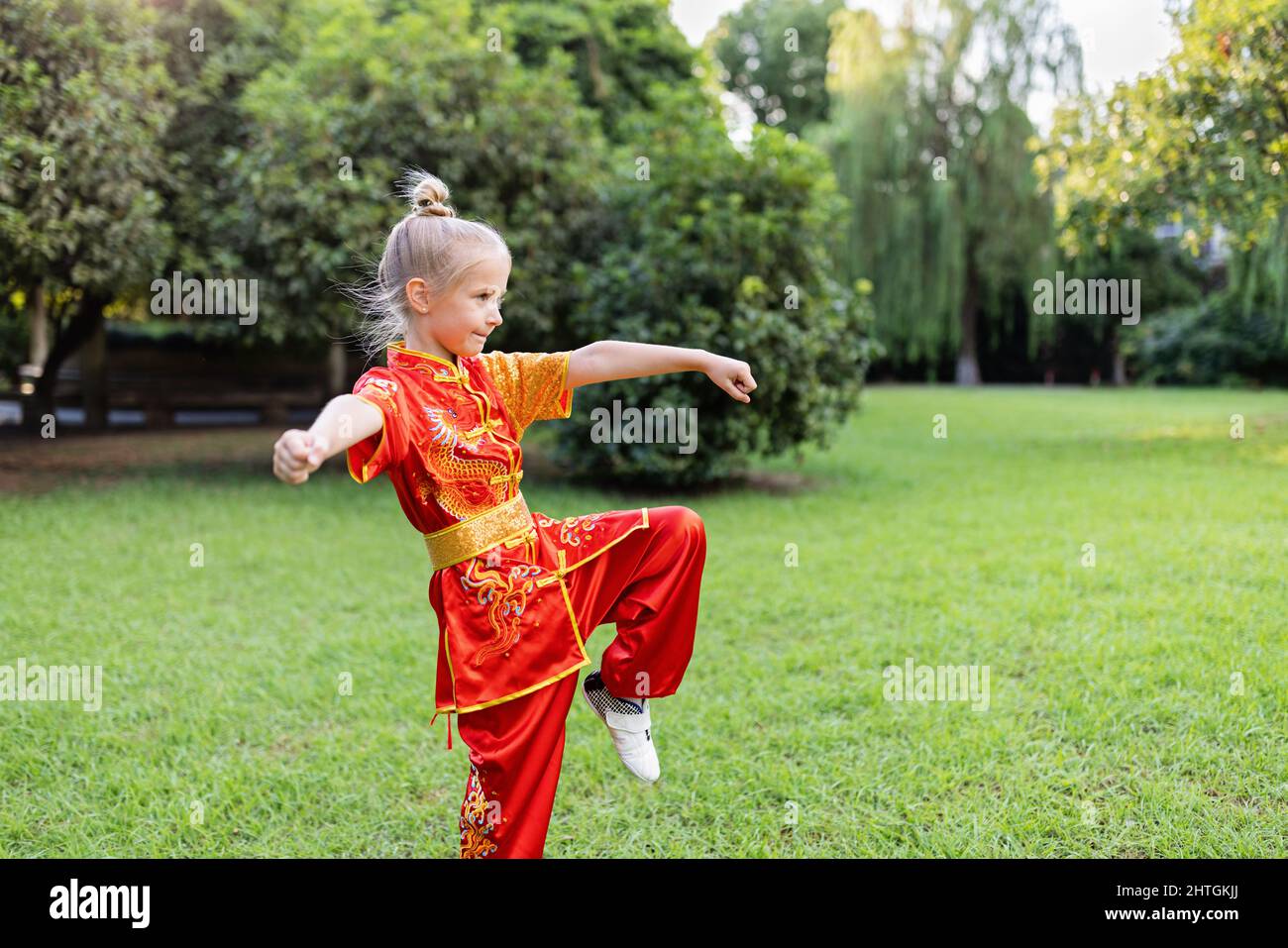 Cute little caucasian girl seven years old in red sport wushu uniform ...
