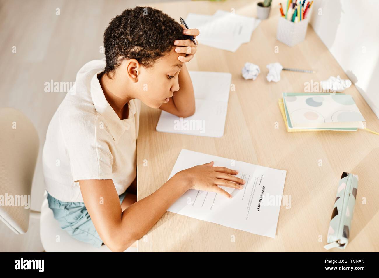 Top view portrait of African American girl struggling with homework and ...