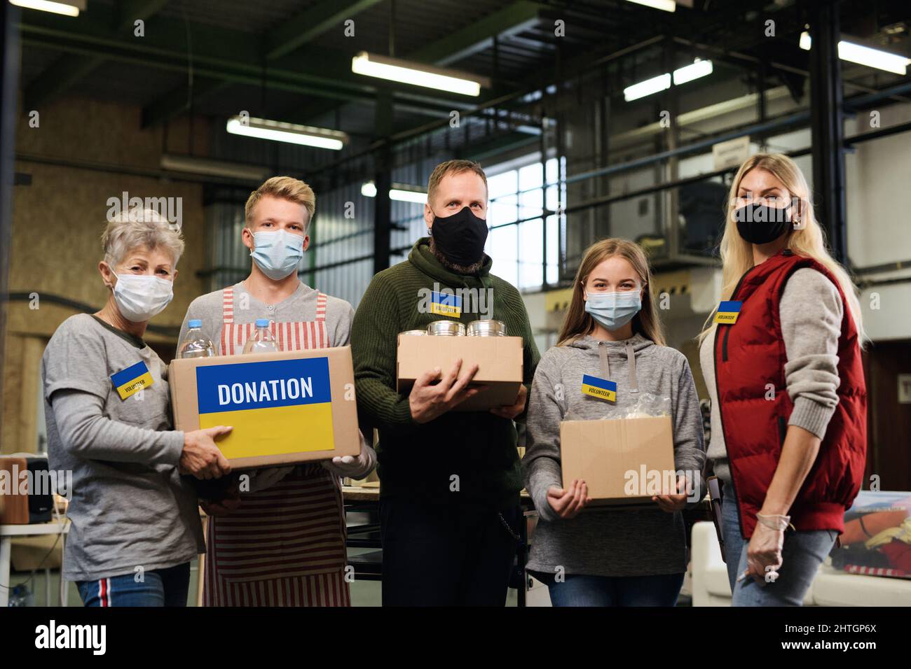 Group of volunteers helping in Ukrainian refugee centre looking at ...