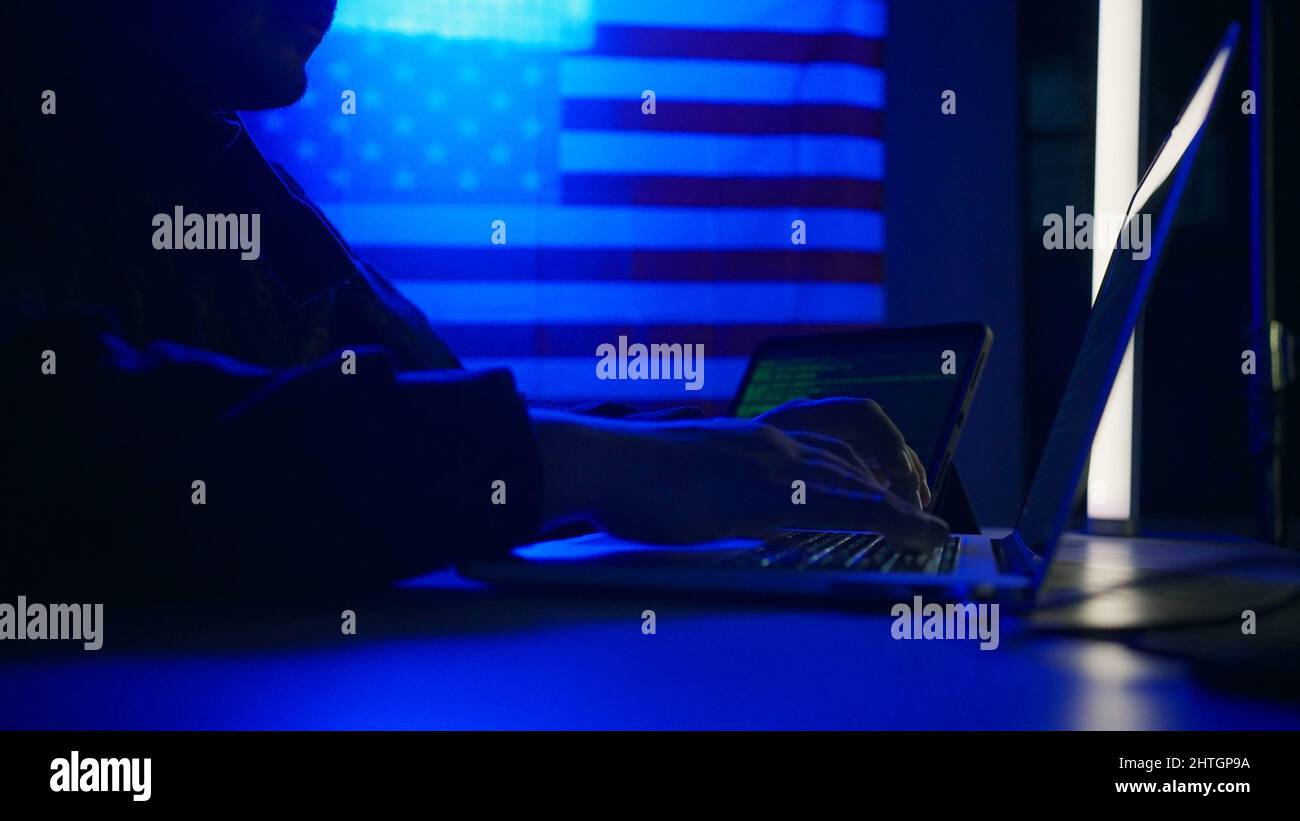 Hacker with laptop and USA flag in background. Cyber attack concept ...