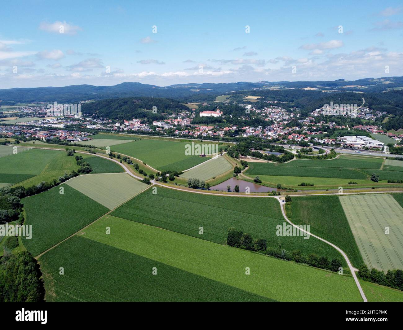 Aerial view of an agricultural green field with community buildings in ...