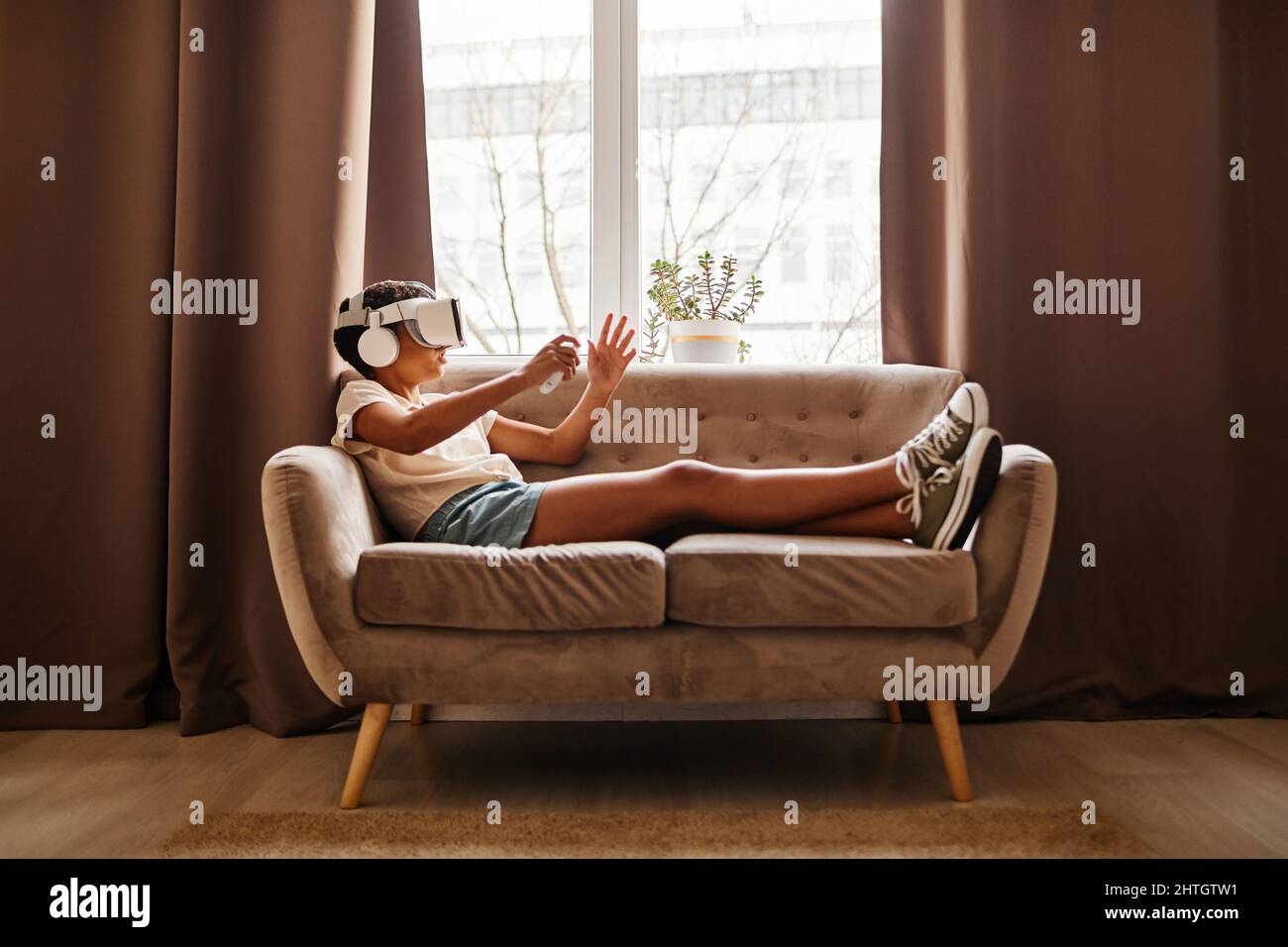 Graphic side view portrait of black teenage girl playing VR game while ...