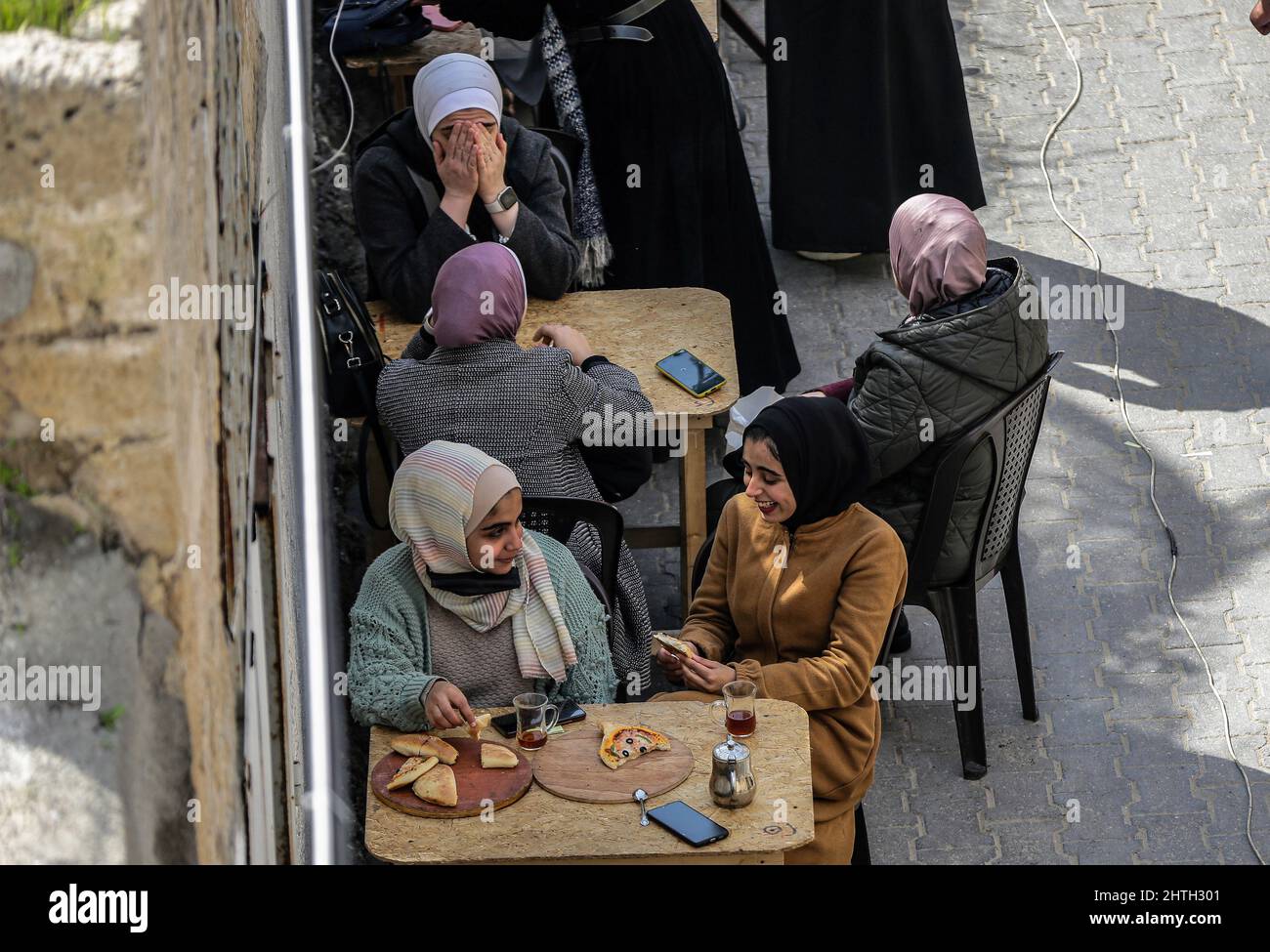 Gaza City, Palestine. 27th Feb, 2022. Palestinians eat food on a street ...