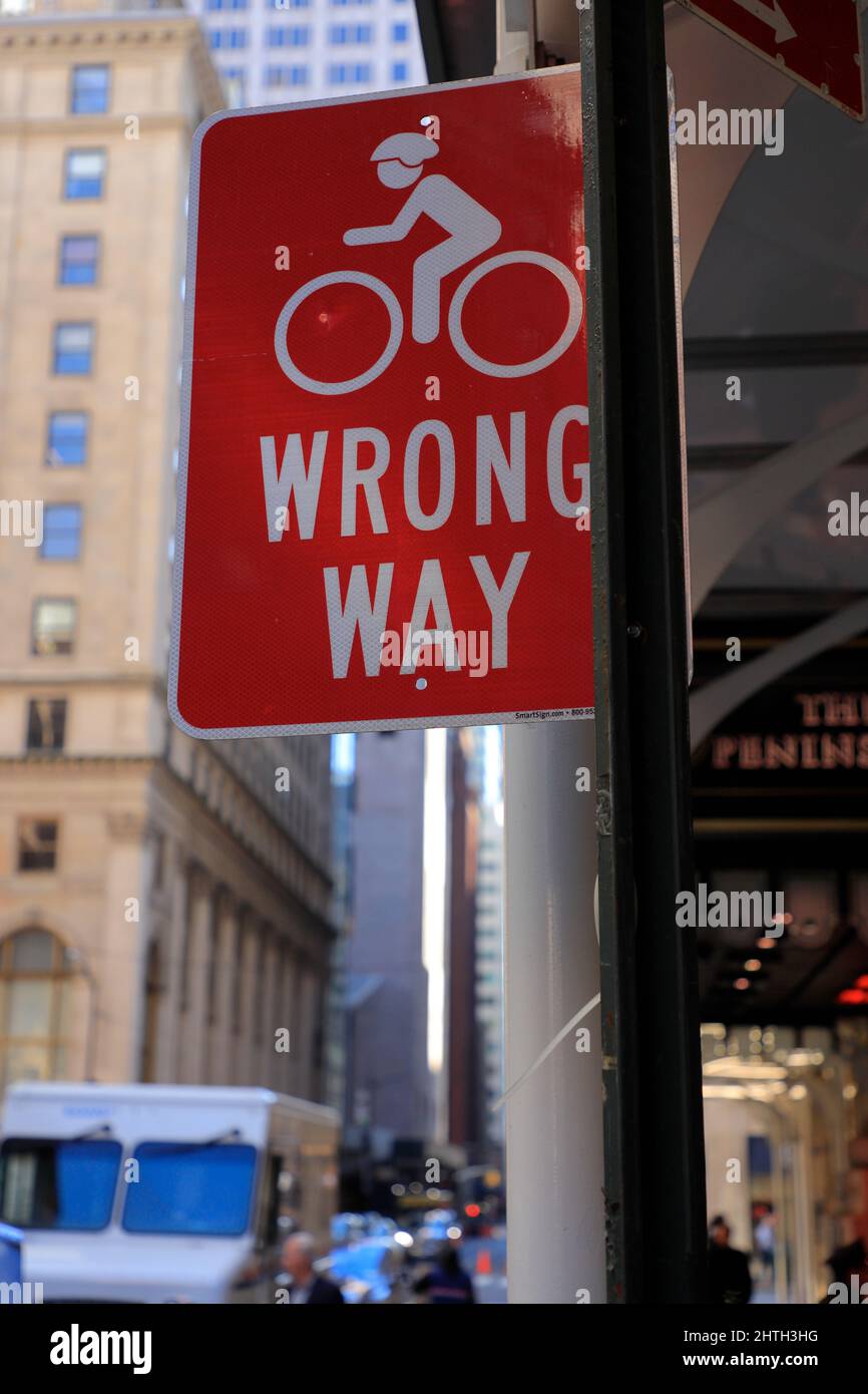 A red warning sign of wrong way for bicycle by the sidewalk on midtown ...