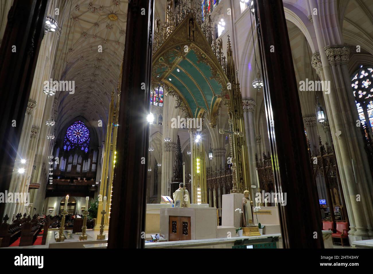 The back of the altar of St. Patrick's Cathedral with a priest giving a ...