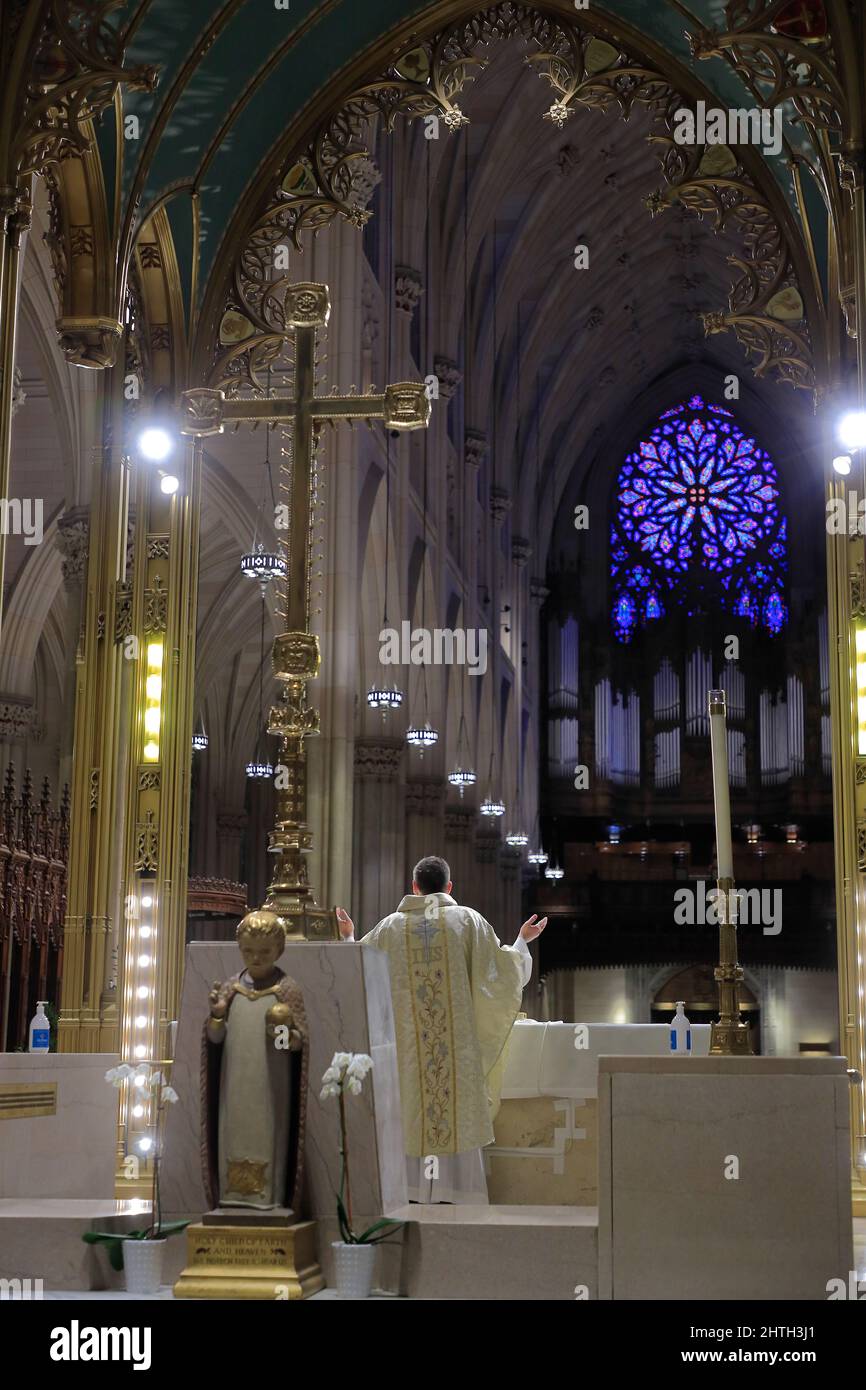 The back of the altar of St. Patrick's Cathedral with a priest giving a ...
