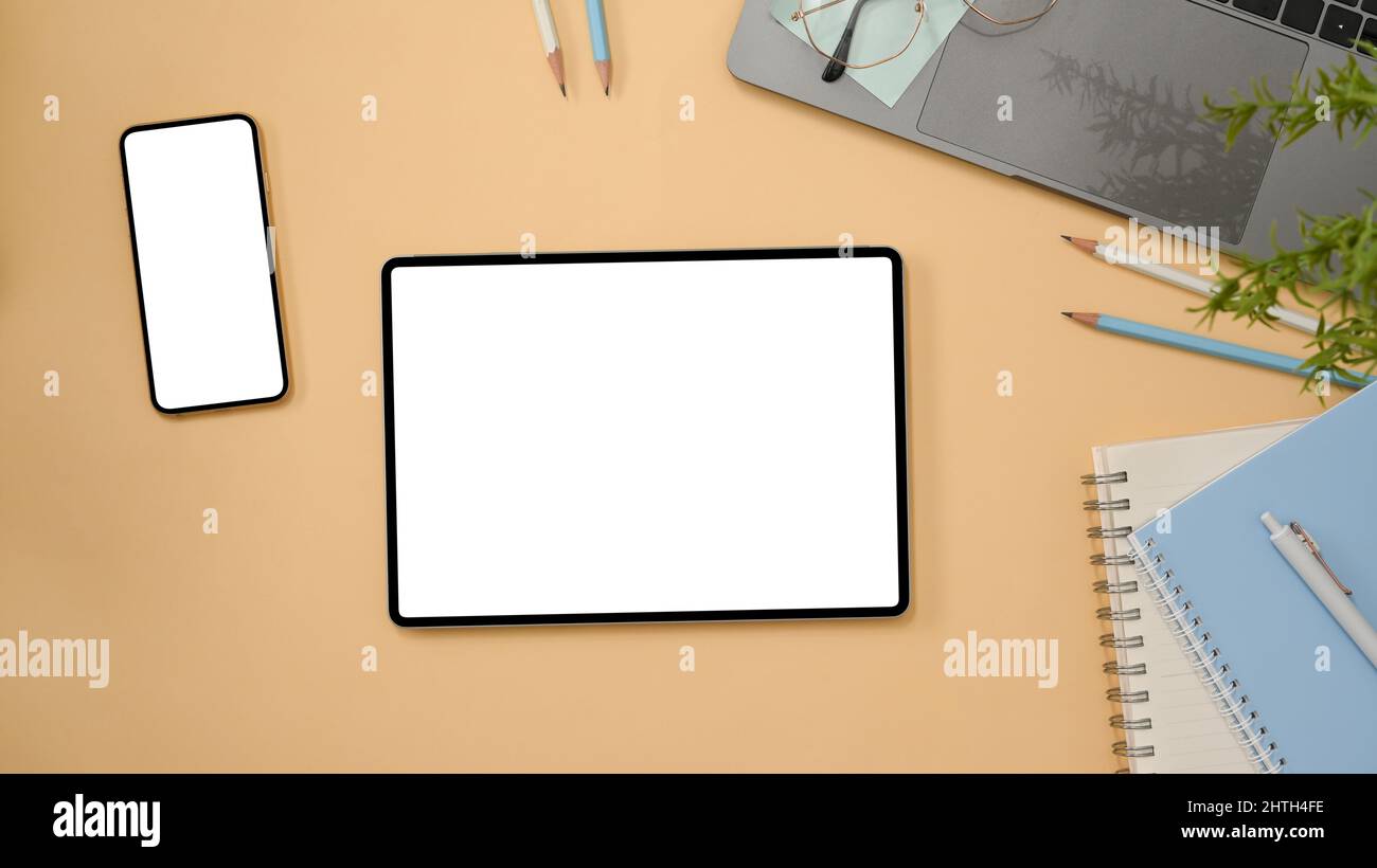 Workspace in beige background with smartphone white screen, tablet ...
