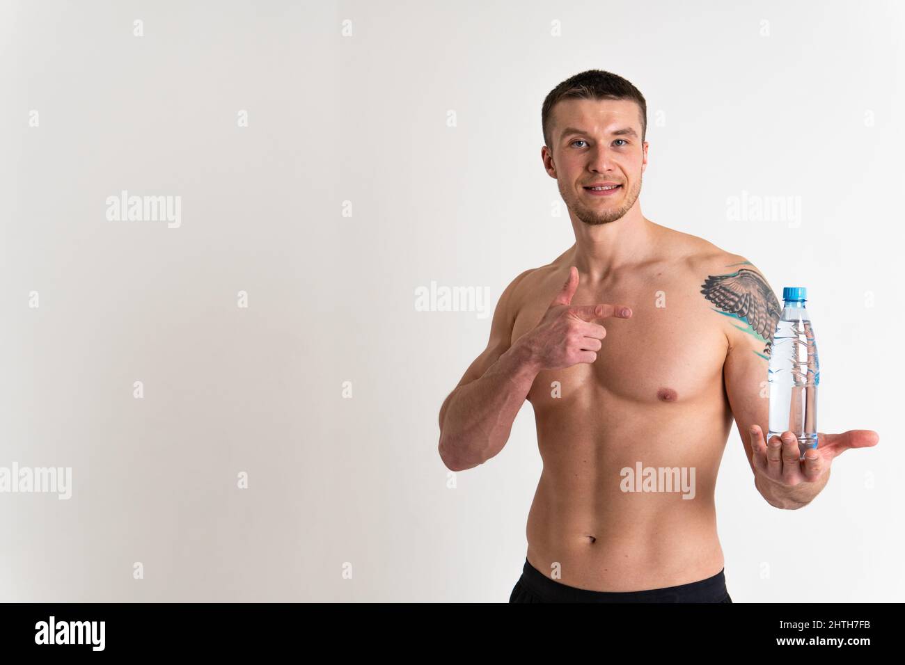 Male drink-water fitness is pumped with a towel on a white background ...