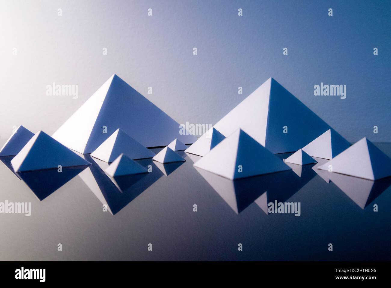 Origami pyramids on reflective glass Stock Photo - Alamy
