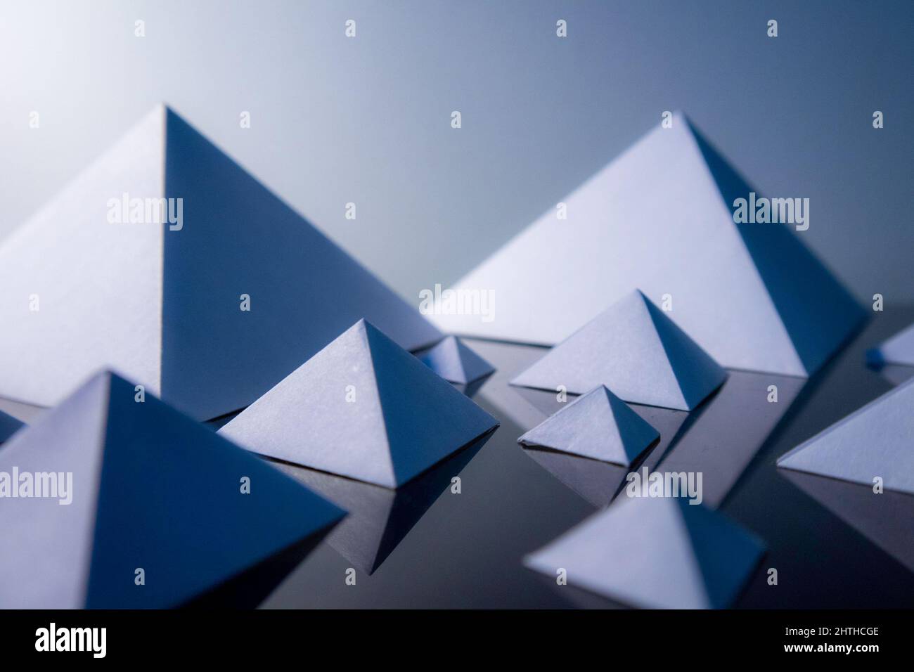 Origami pyramids on reflective glass Stock Photo - Alamy
