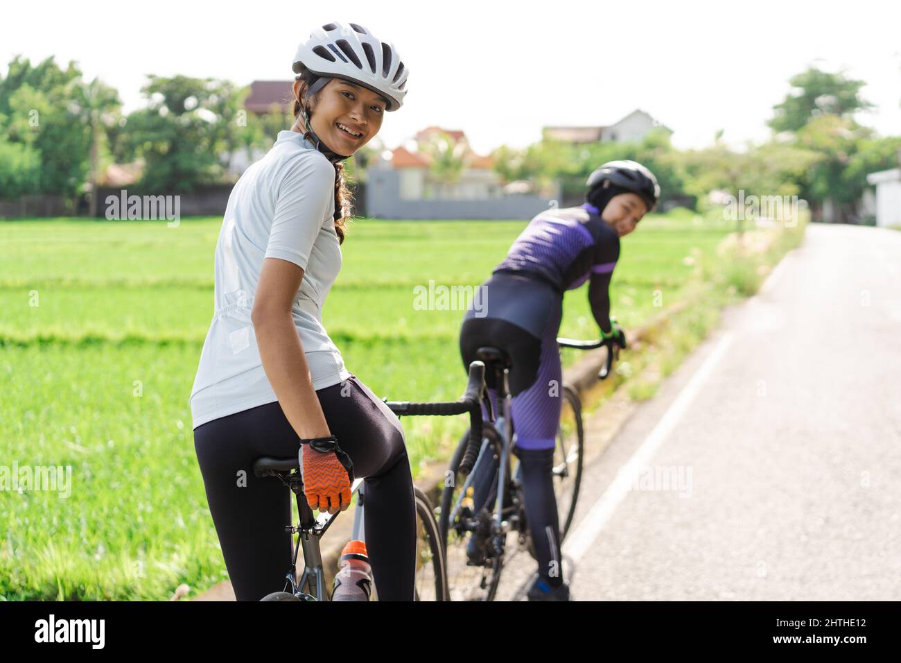 cyclist and friend riding her bike together at the city street Stock ...