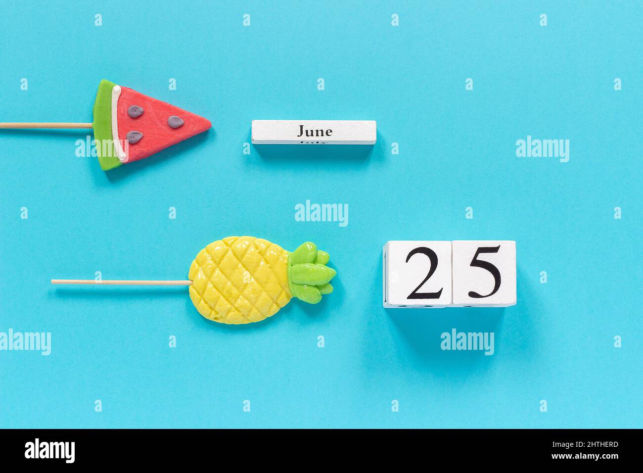 Wooden cubes calendar date June 25th and summer fruits candy pineapple ...