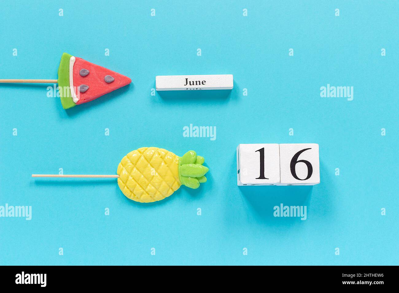 Wooden cubes calendar date June 16th and summer fruits candy pineapple ...