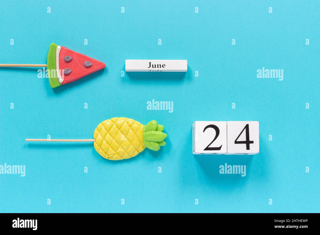 Wooden cubes calendar date June 24th and summer fruits candy pineapple ...