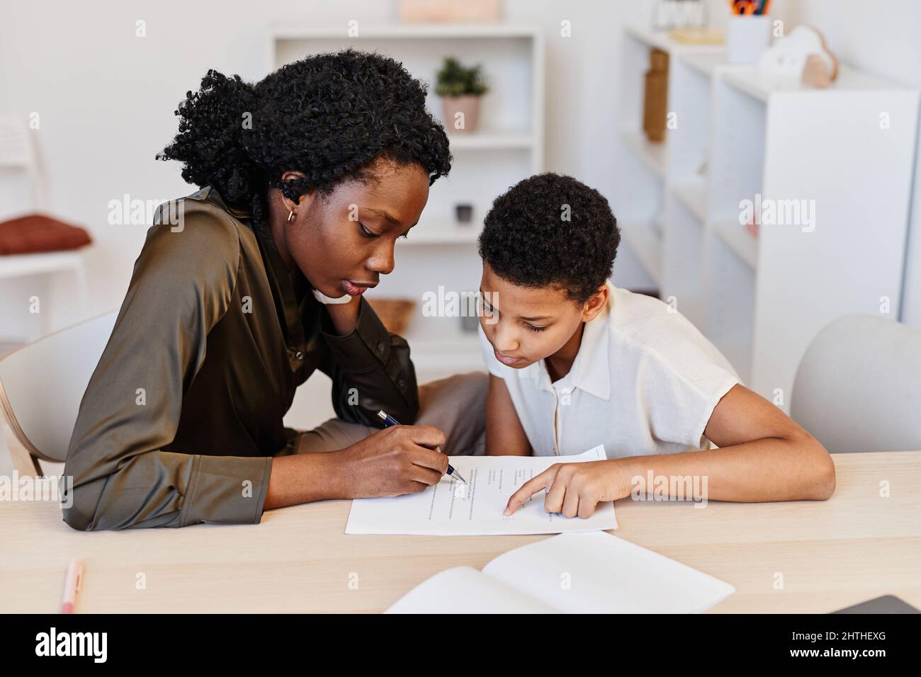 Portrait of African American female tutor helping teenage girl ...