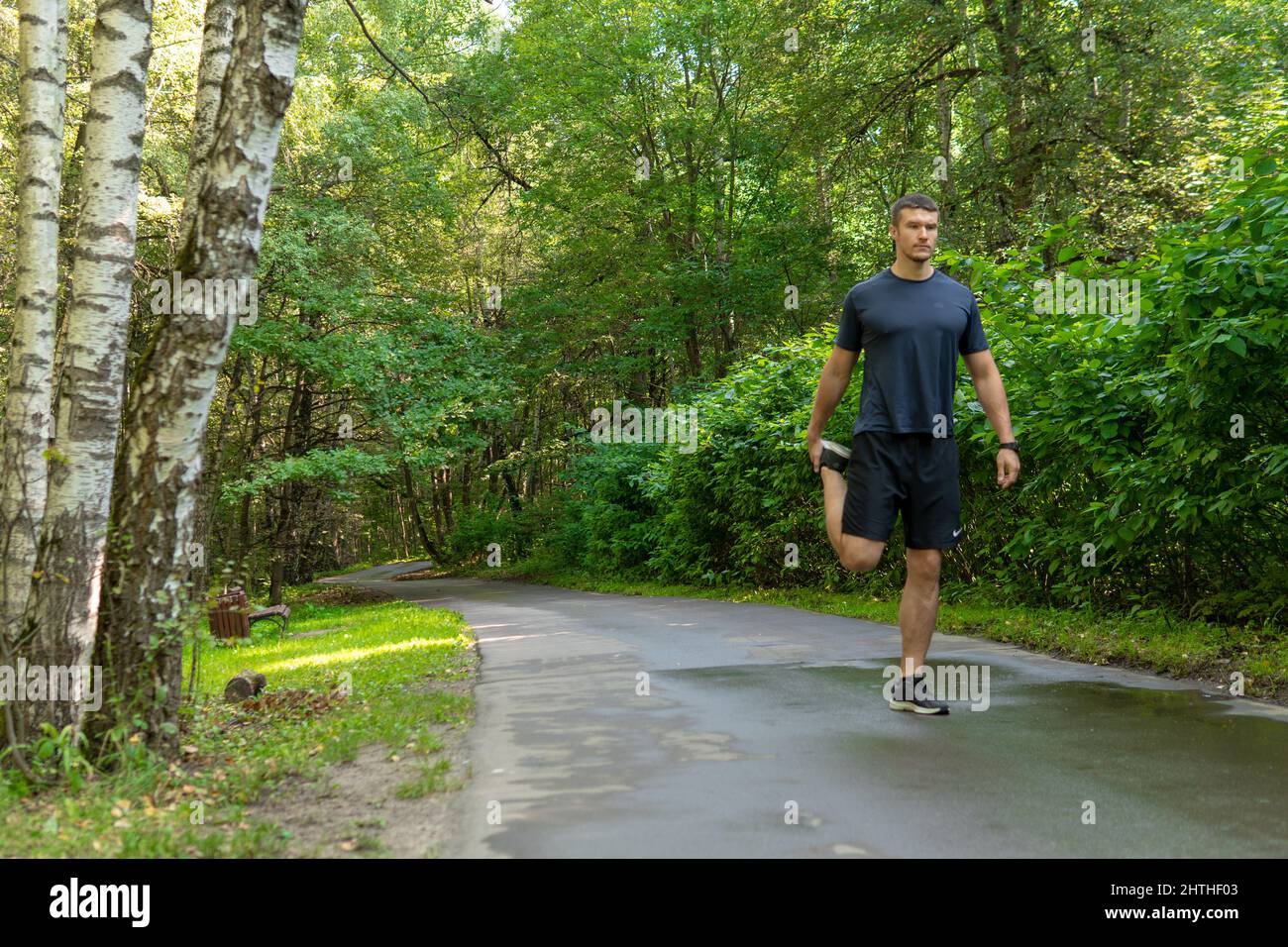 A man athlete runs in the park outdoors, around the forest, oak trees ...