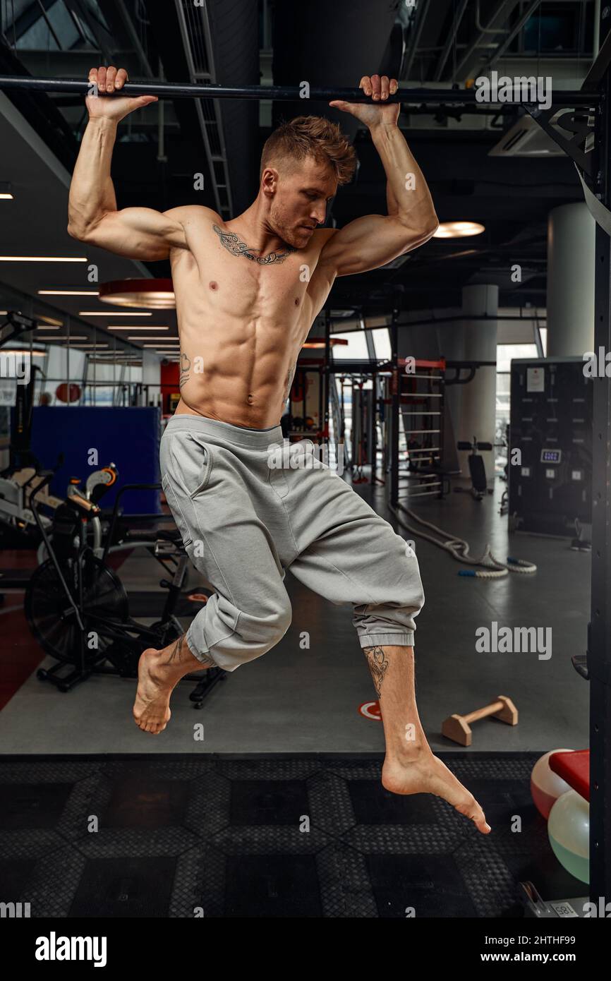 Muscular strong man exercising in the sport gym, Man doing horizontal ...