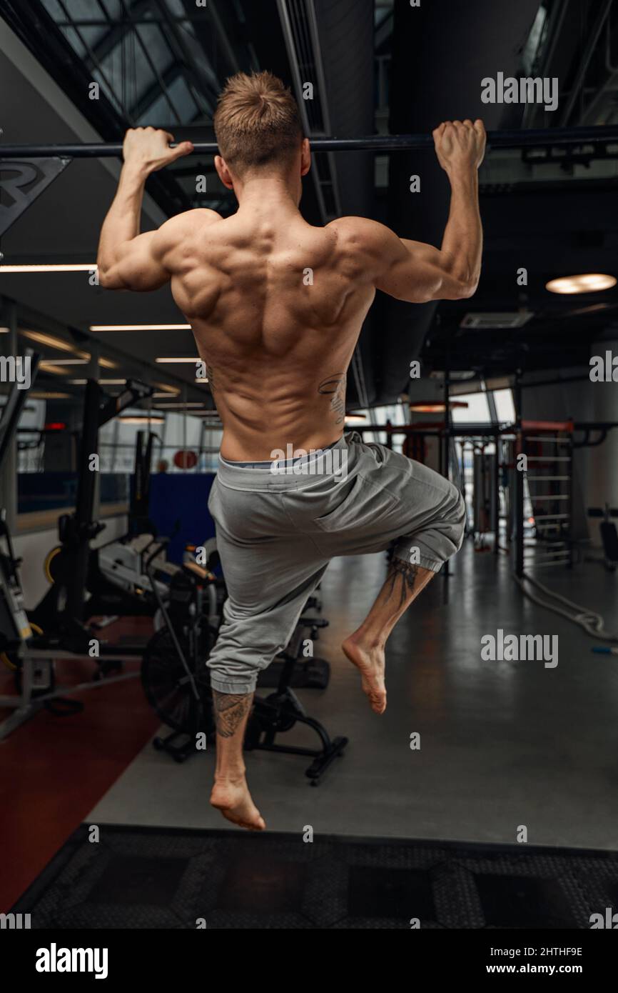 Muscular strong man exercising in the sport gym, Man doing horizontal ...