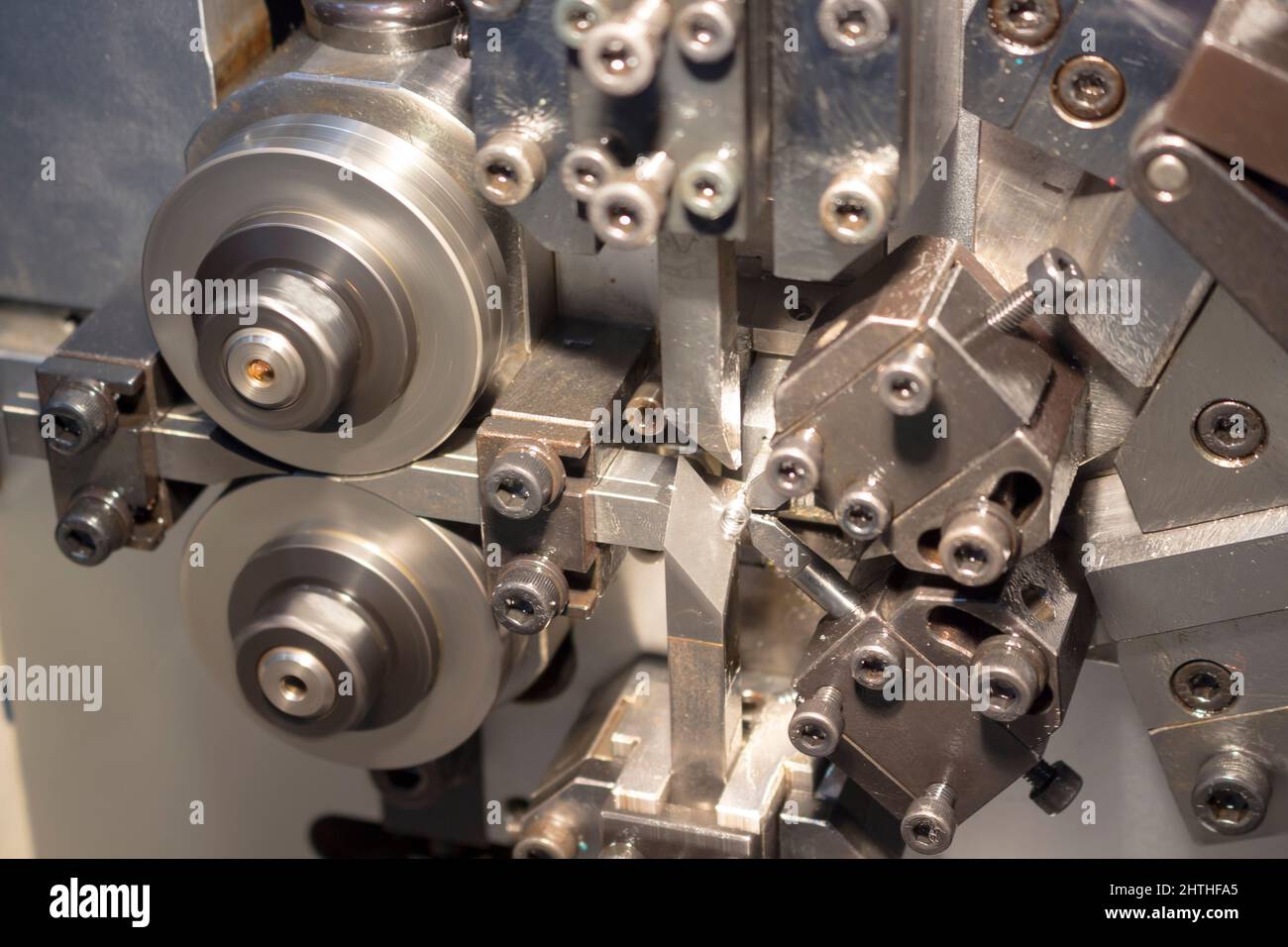 Blurred picture of small spring making machine ; industrial background ...