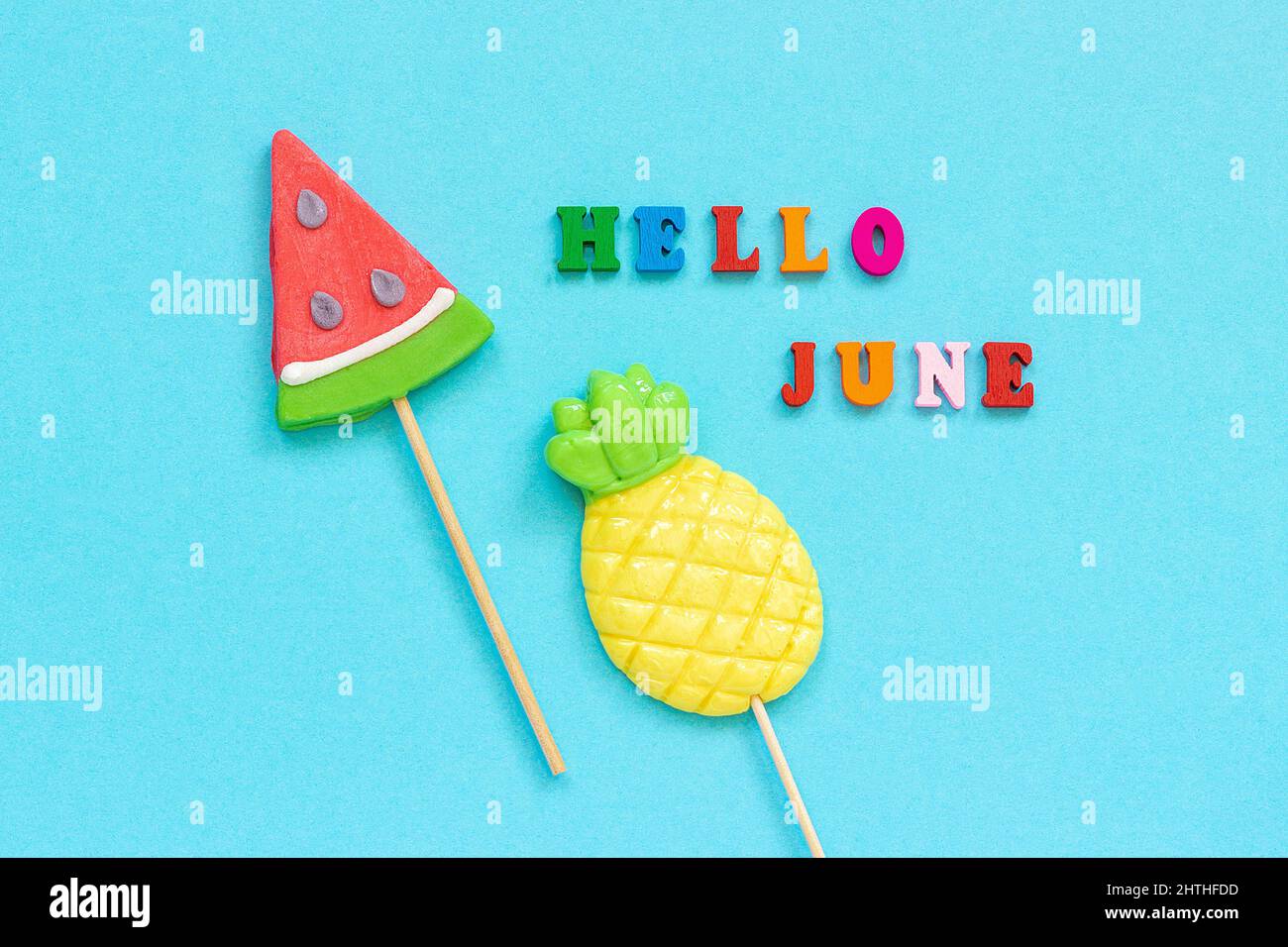 Hello June colorful text, pineapple and watermelon lollipops on stick ...