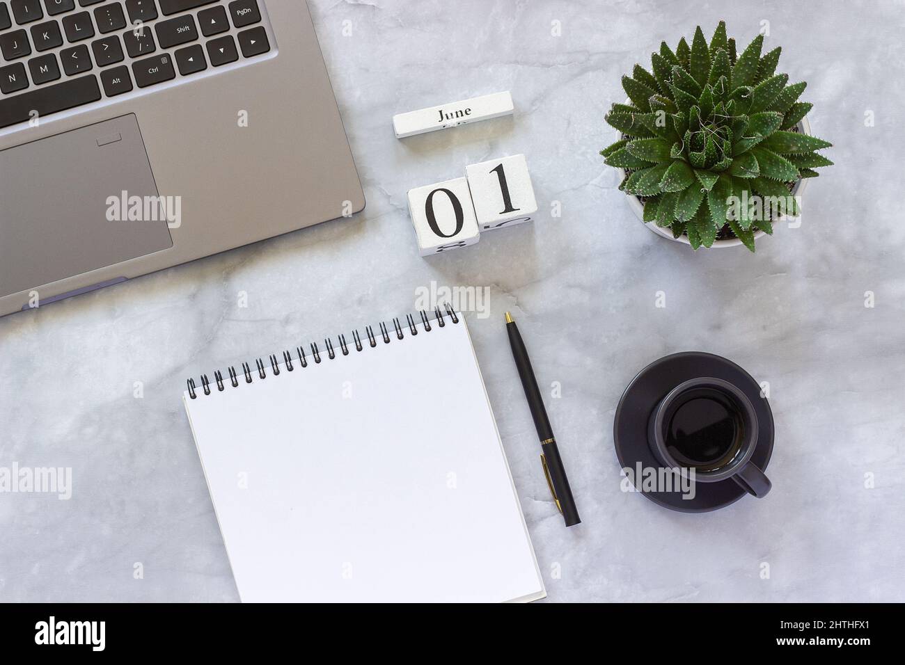 Office or home table desk. Wooden cubes calendar June 1st. Gray laptop ...