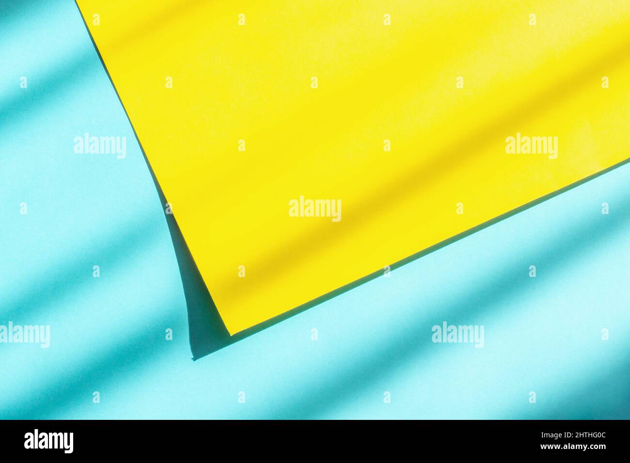 abstract blue and yellow paper background with hard light and shadow ...