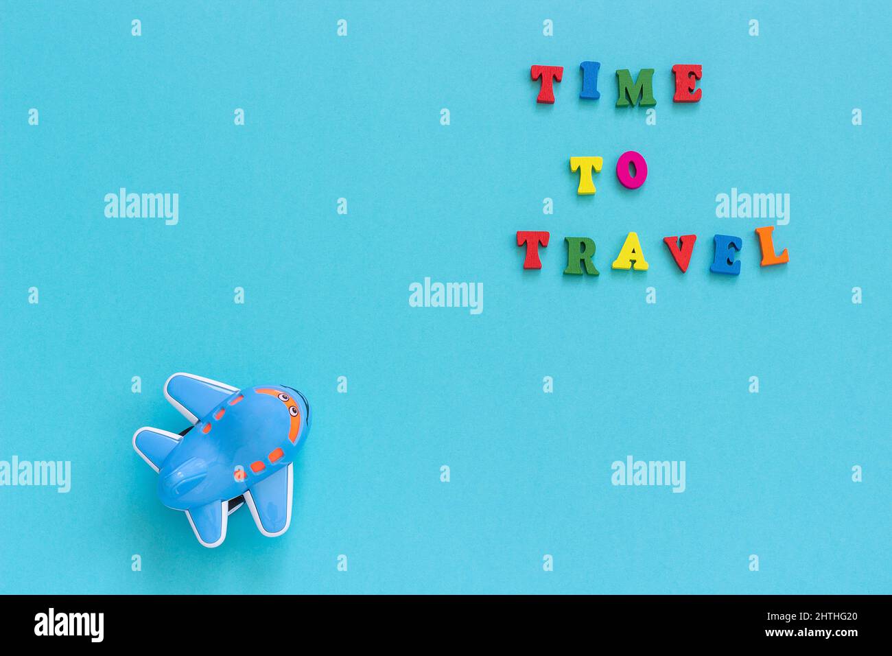 Colorful text Time to travel and children's funny toy plane on blue ...
