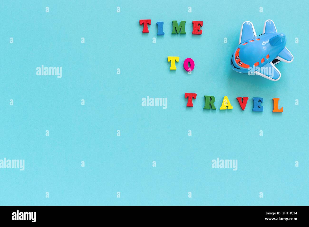 Colorful text Time to travel and children's funny toy plane on blue ...