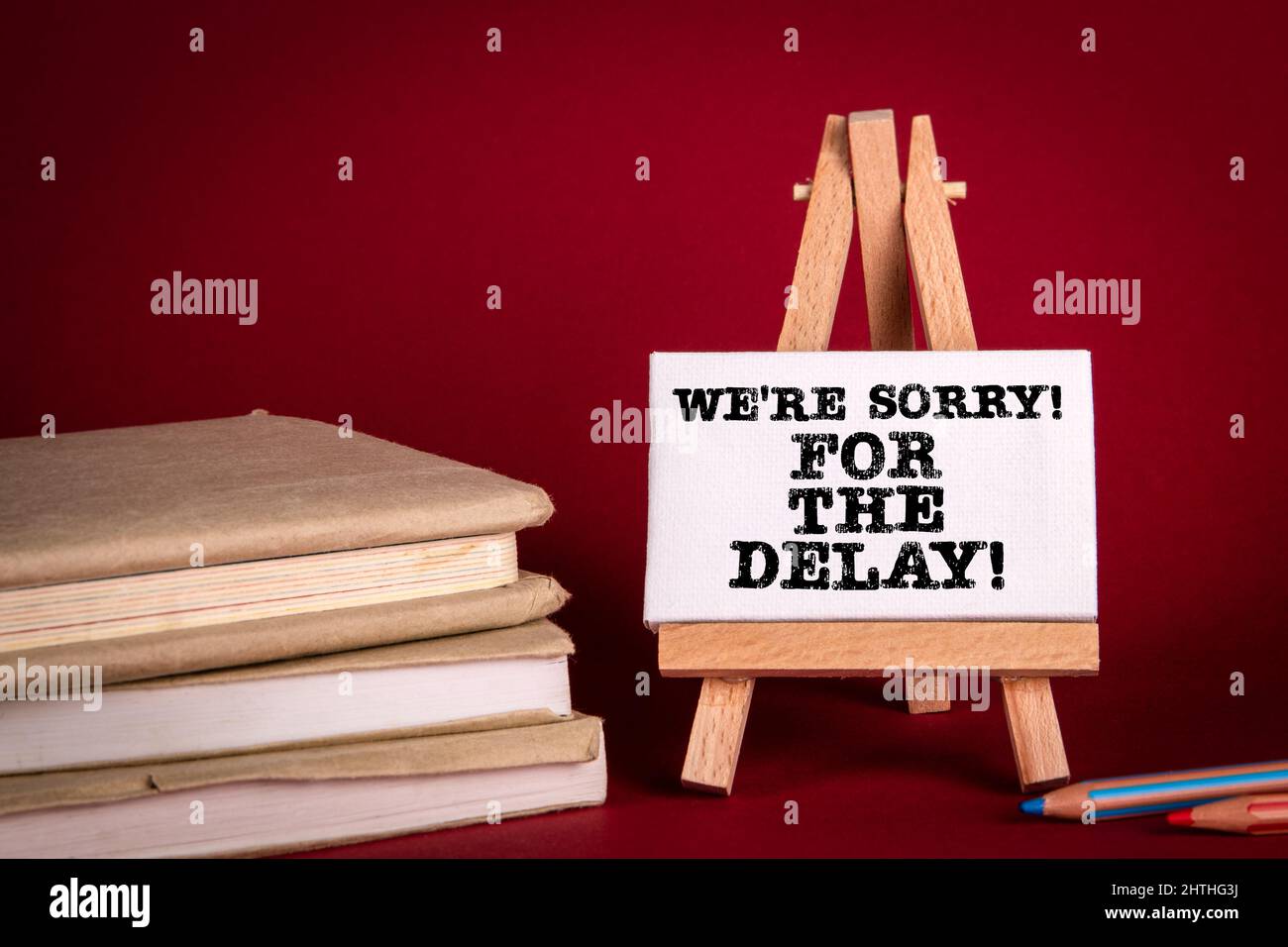 We're Sorry For The Delay. Miniature easel on a red background Stock ...