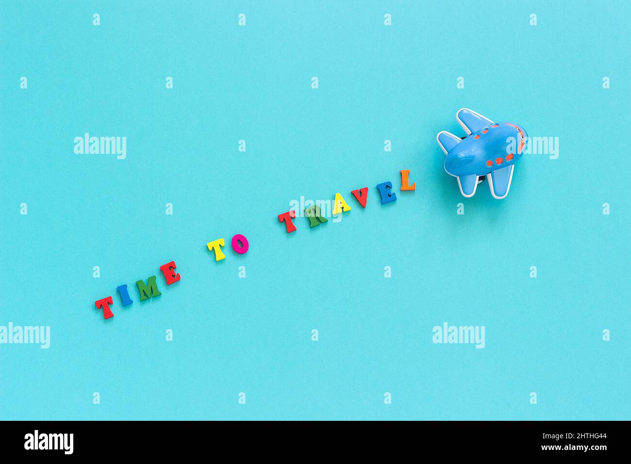 Colorful text Time to travel and children's funny toy plane on blue ...
