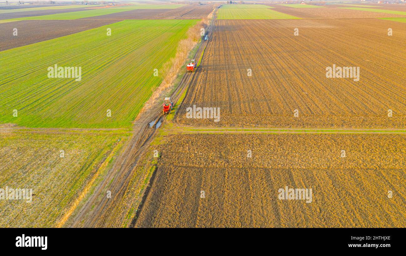 Above view of tractor, he is dragging trailer full of stuffed sacks ...