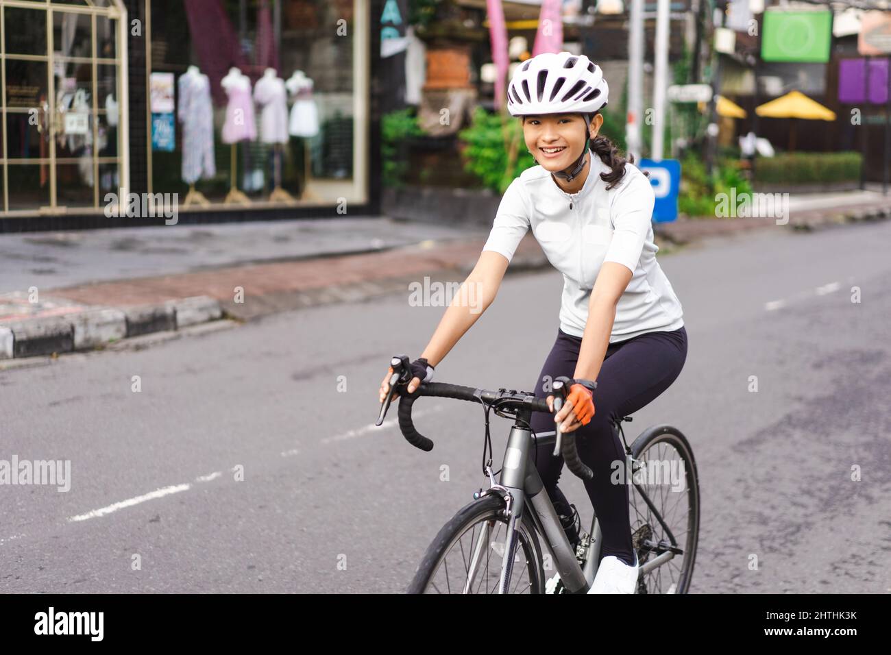 female riding a road bike in the city street Stock Photo - Alamy