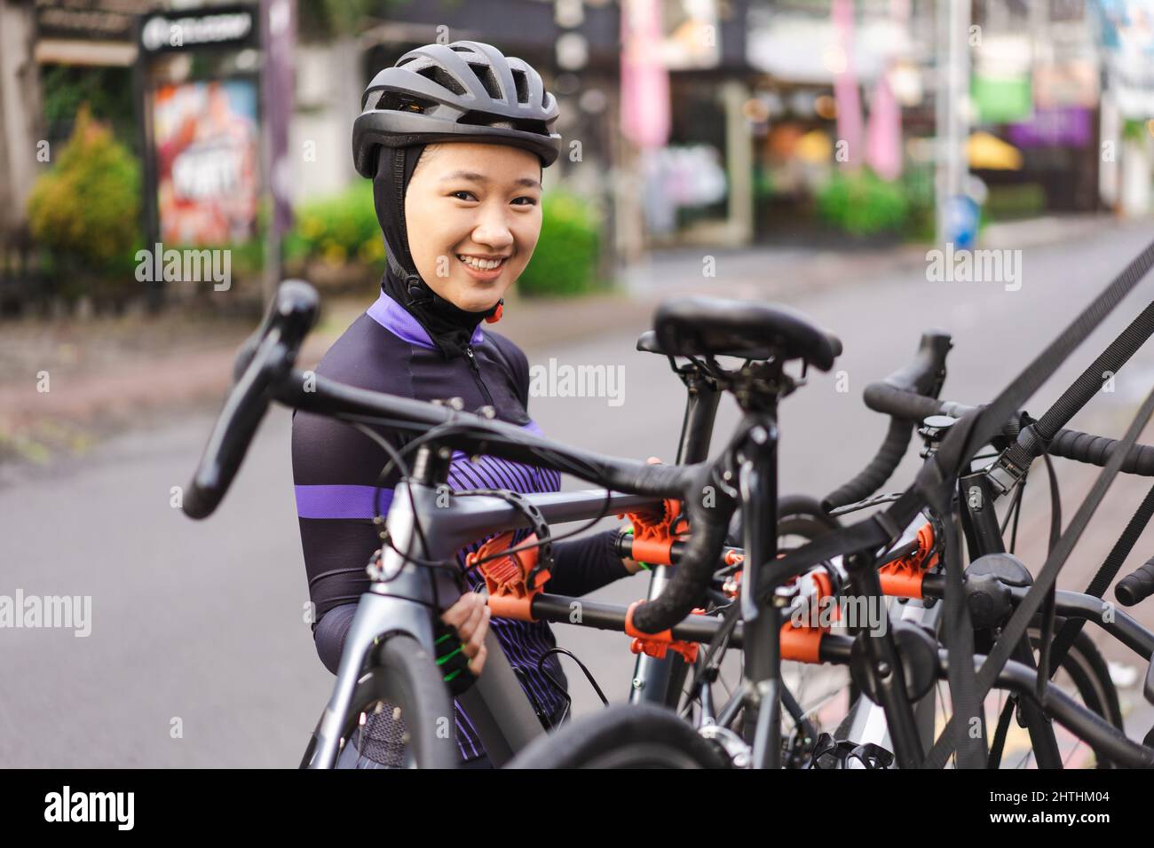 muslim female cyclist unloading her road bicycle on a rack in the back ...