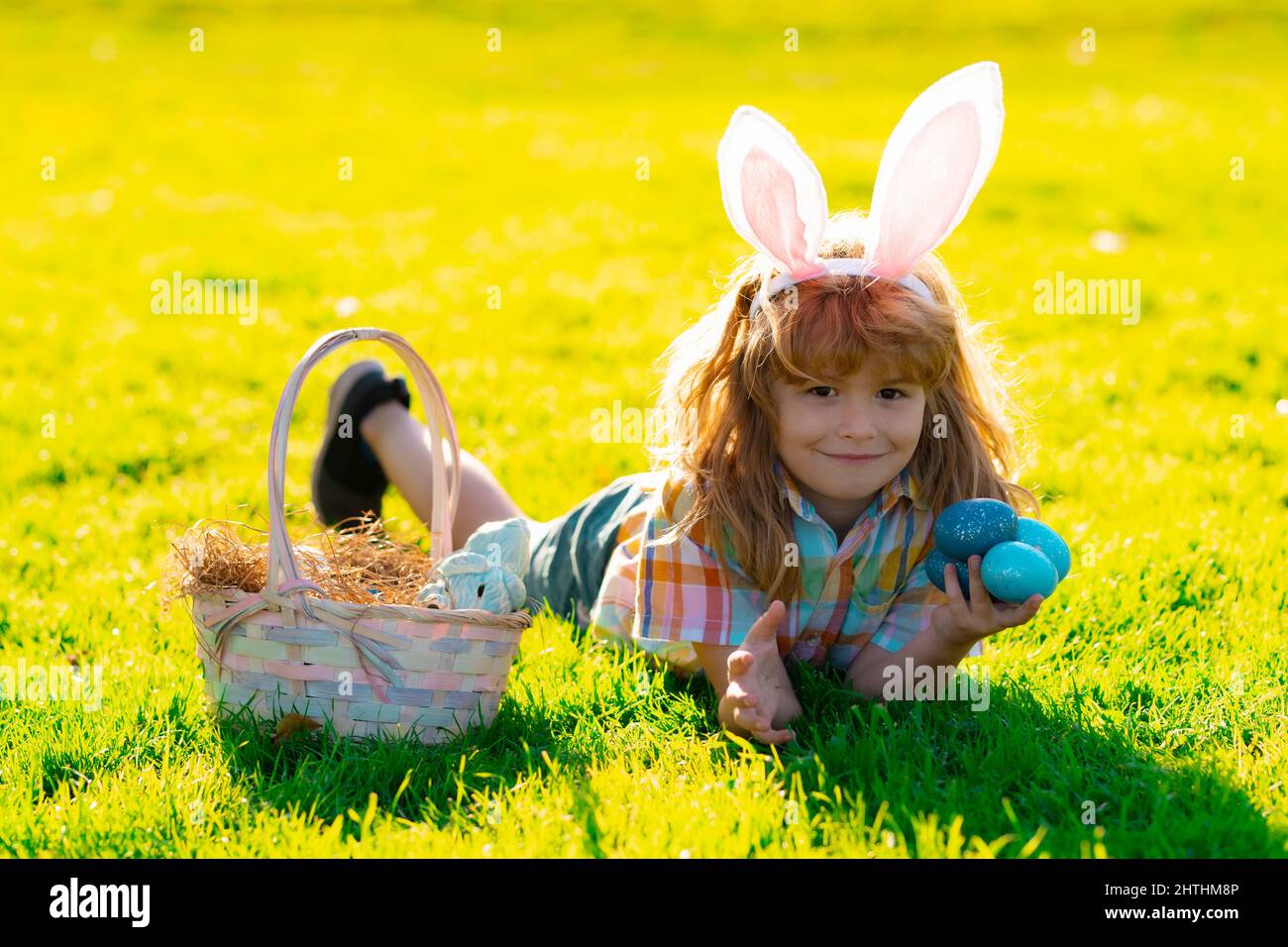 Child boy hunting easter eggs. Cute kid in rabbit costume with bunny ...