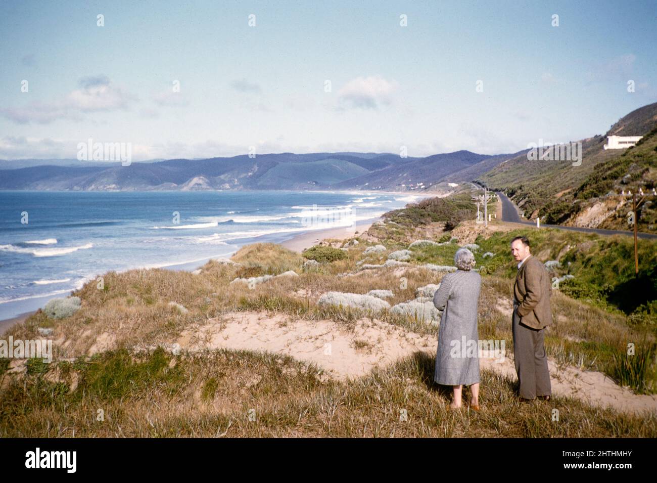 Man and woman standing in sand dunes by sandy beach near Anglesea ...