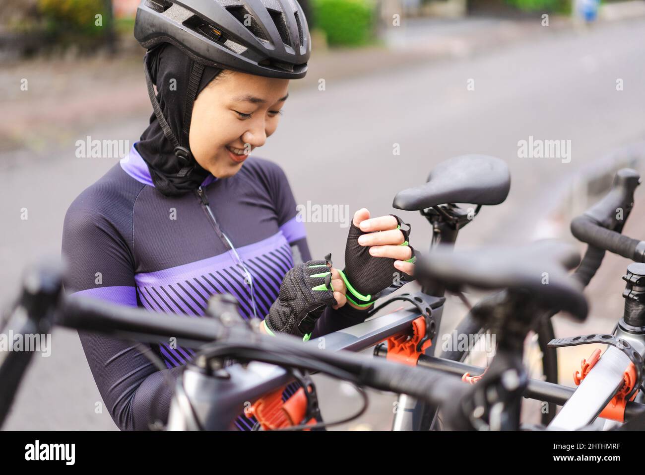 muslim female cyclist unloading her road bicycle on a rack in the back ...