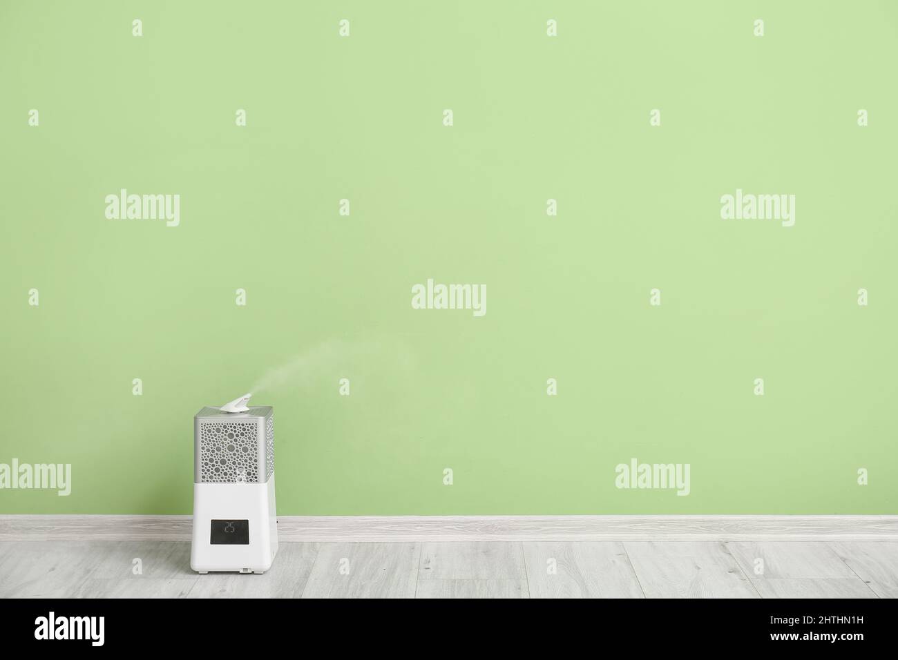 Modern humidifier near color wall Stock Photo - Alamy