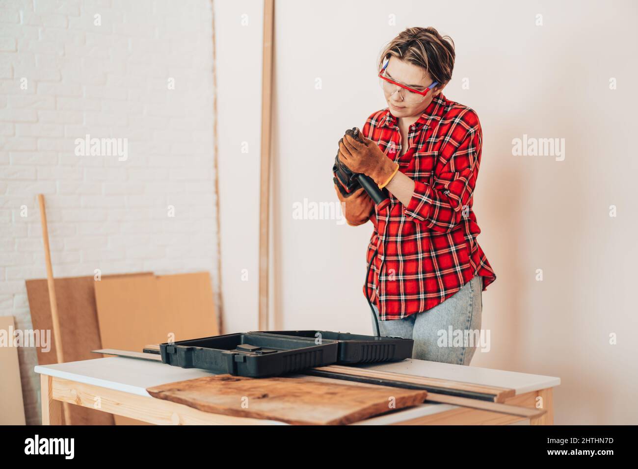 Laborer girl inserts drill into drill Stock Photo - Alamy