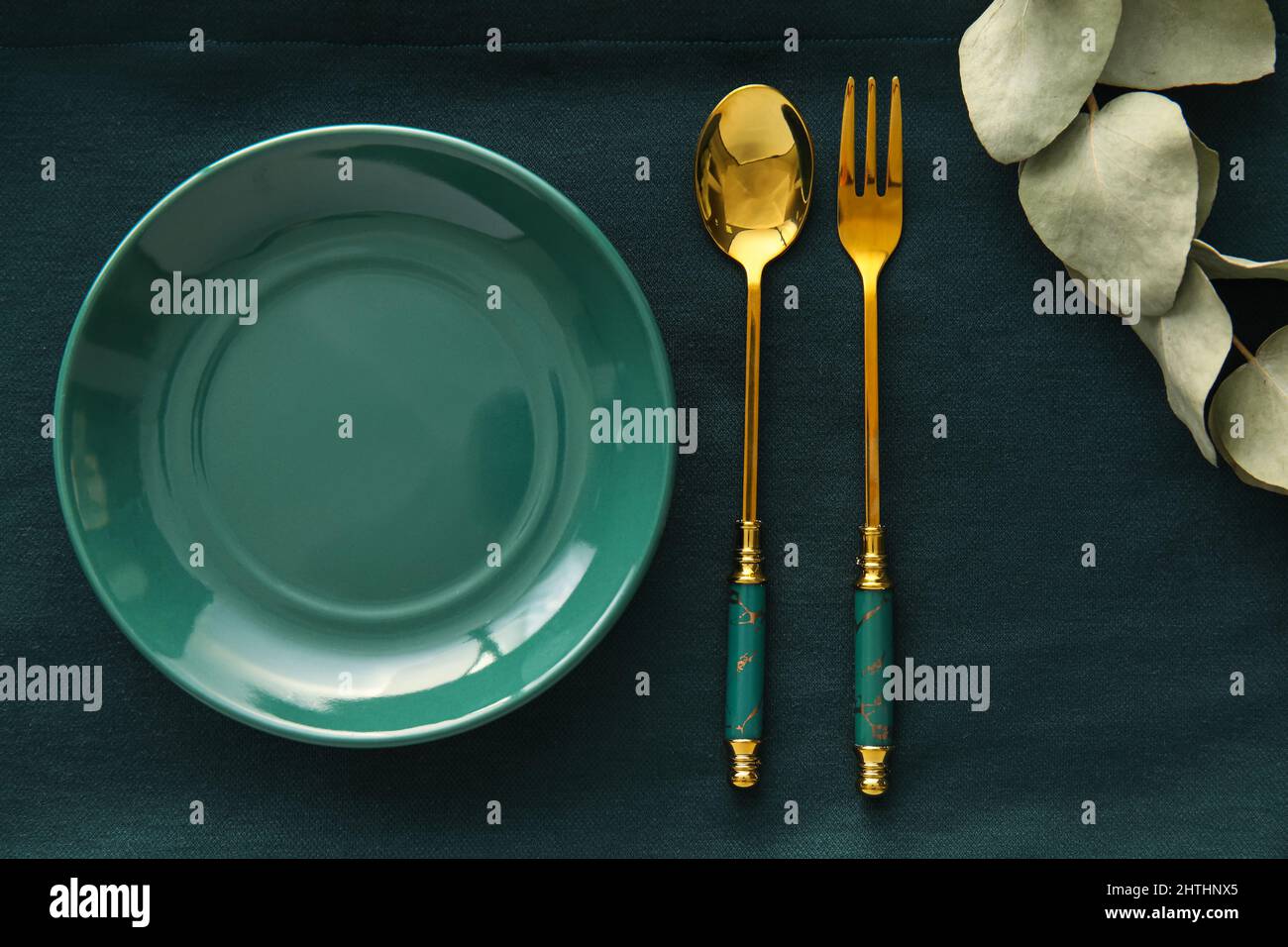 Elegant table setting on green fabric background Stock Photo - Alamy