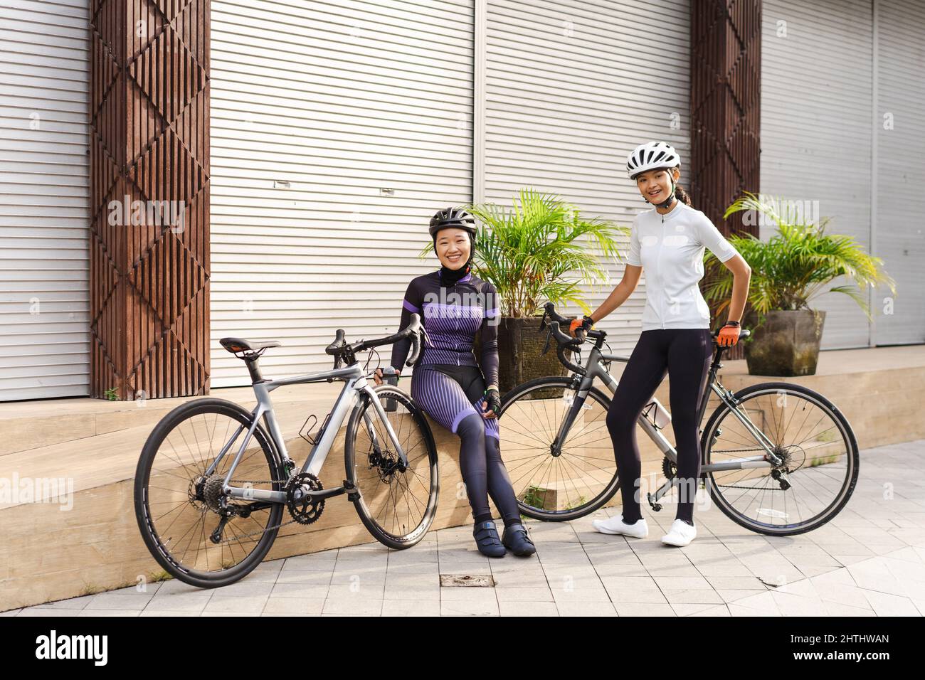 excited two muslim female cyclist with her bike Stock Photo - Alamy