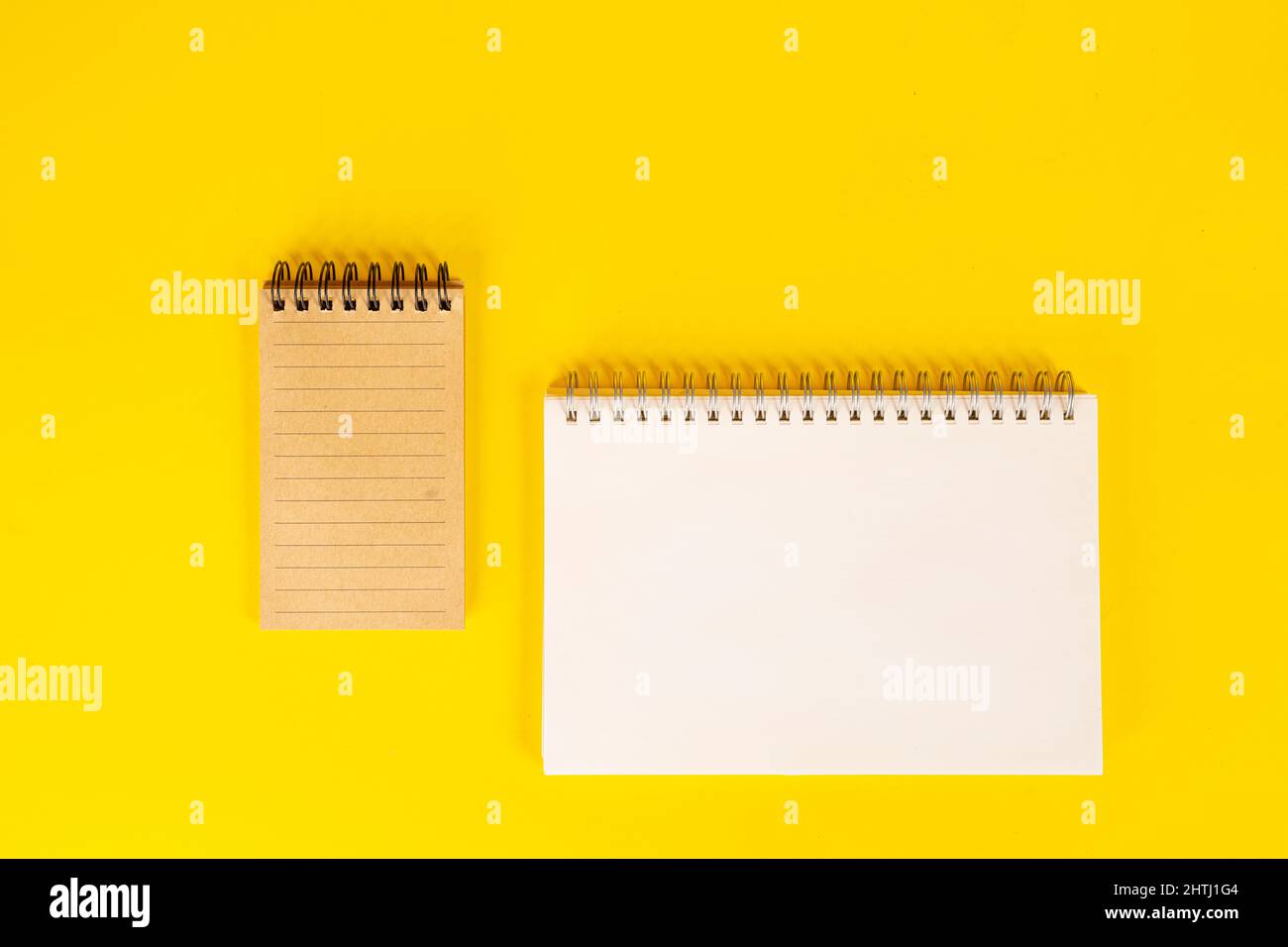 two blank notepads on a yellow background surface Stock Photo - Alamy