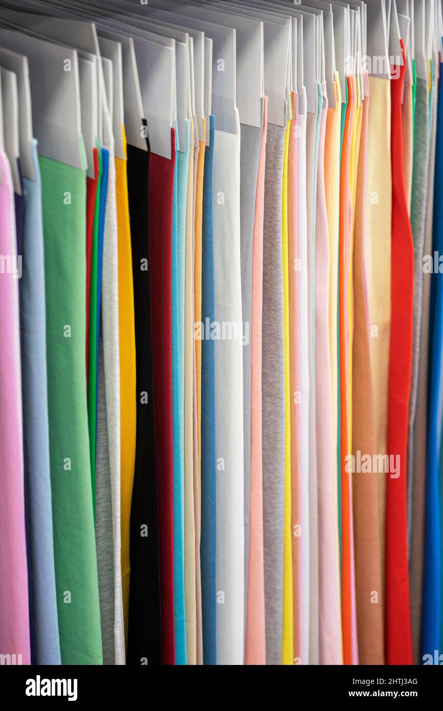 Colorful fabric samples in row on hanger. Sewing clothes for designers ...