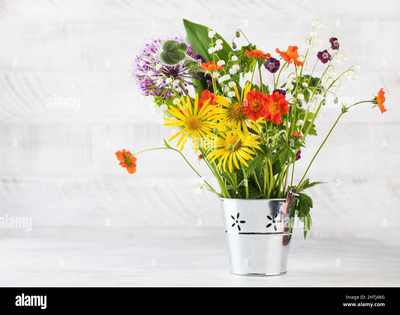 Beautiful summer flowers in a metal bucket. Summer background. Copy ...