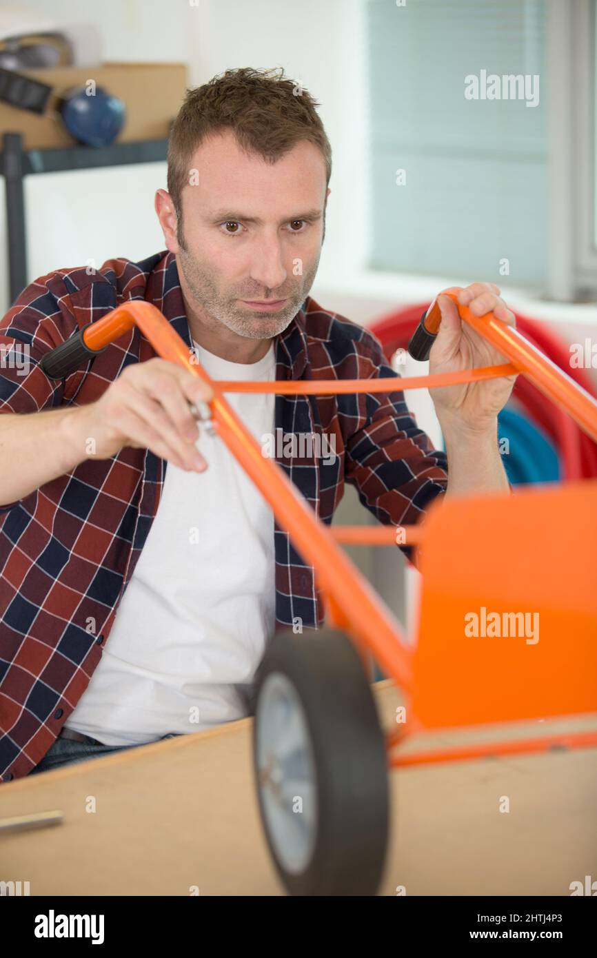 handyman assembling a wheeled trolley Stock Photo - Alamy