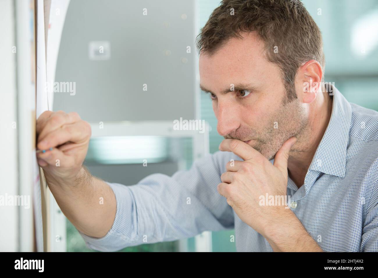 contemplative man stood at notice board Stock Photo - Alamy