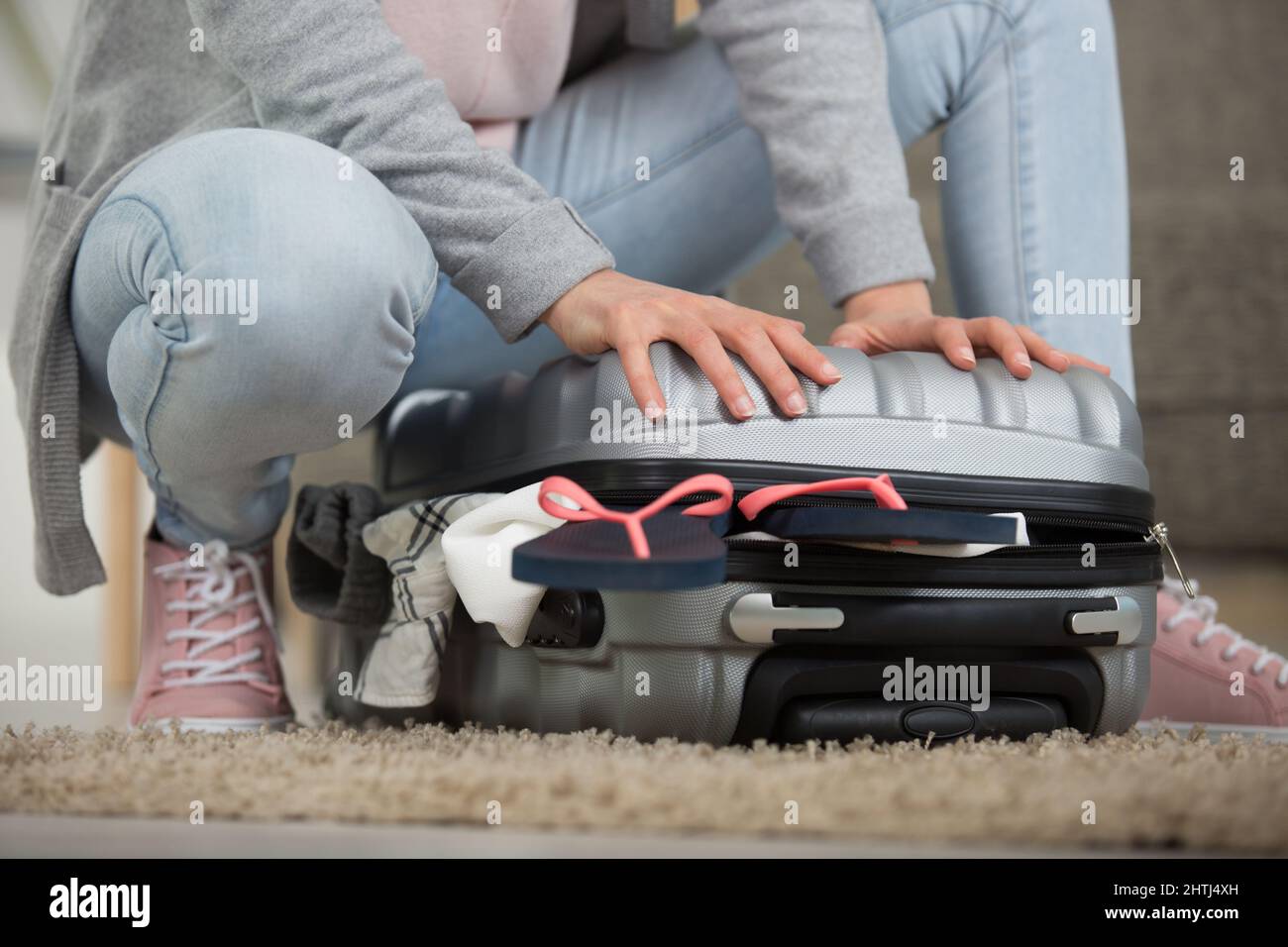 woman struggling to pack suitcase Stock Photo - Alamy