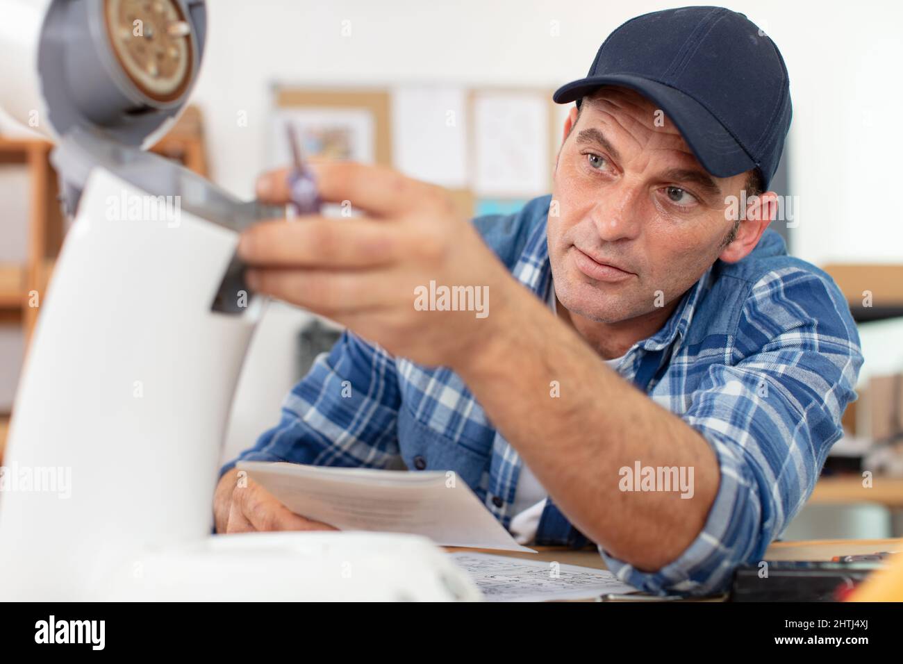 serious man repairing broken coffee machine Stock Photo - Alamy