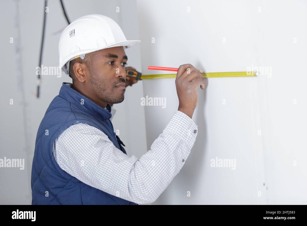 man measures a wall with a tape measure Stock Photo - Alamy
