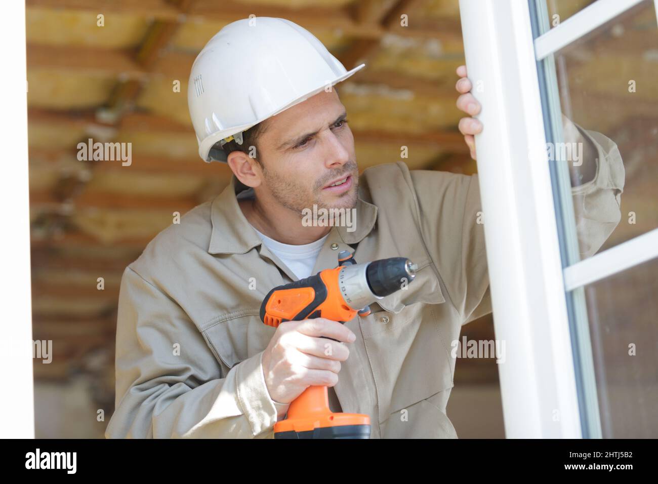 a man drilling window frame Stock Photo - Alamy