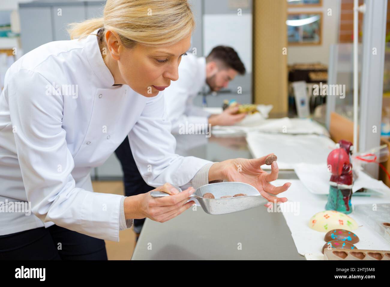 blonde female worker in chocolate in store Stock Photo - Alamy